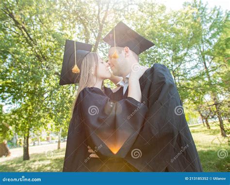 Un Chico Y Una Chica Graduados En Batas Se Paran En El Parque De La