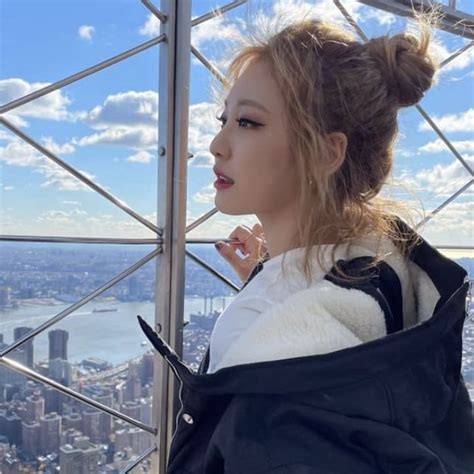 A Woman Standing On Top Of A Tall Building Looking At The City Below