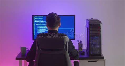 Programmer Coding On A Computer In The Dark With A View Of The Lights
