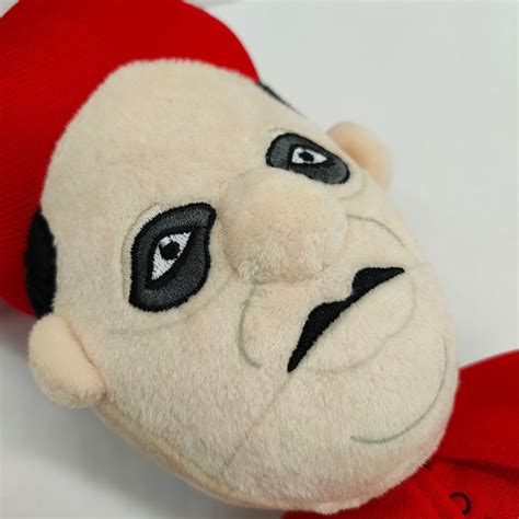 A Teddy Bear With A Red Scarf Around It S Neck And Eyes On A White Surface