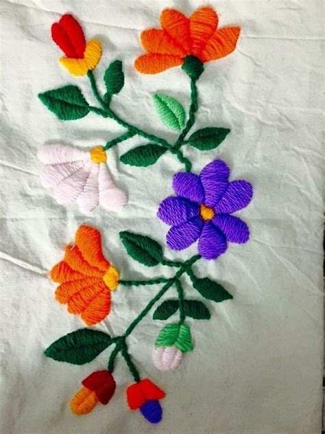 An Embroidered Piece Of Cloth With Flowers On It