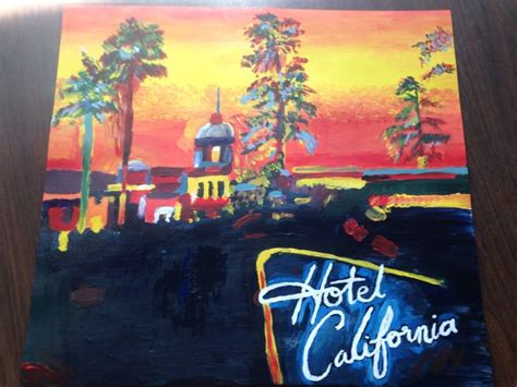 The Hotel California Sign Is Painted On A Wooden Surface With Palm