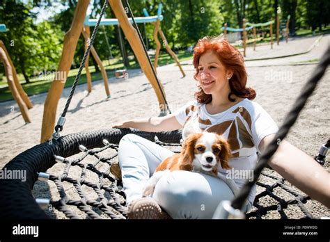 Femme mature se balancer avec son ami des animaux à l extérieur de jeu