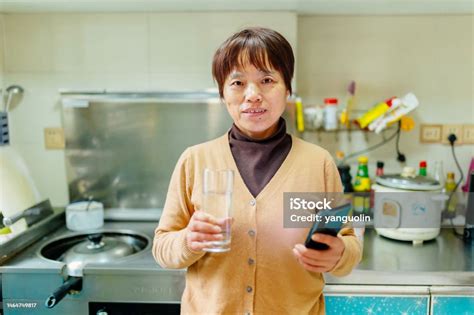 단순한 삶 중년 여성은 부엌에서 컵으로 물 한 잔을 마 십니다건강한 라이프 스타일 40 44세에 대한 스톡 사진 및 기타 이미지 40 44세 가구 가정 생활 Istock