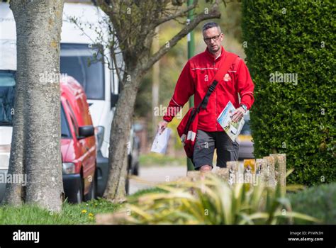 Royal Mail Postman Walking Carrying Letters For Delivery In England UK