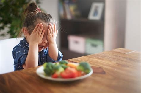 La niña no quiere comer verduras Foto Gratis