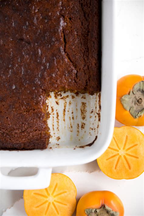 A Close Up Of A Cake In A Pan On A Table With Fruit Around It
