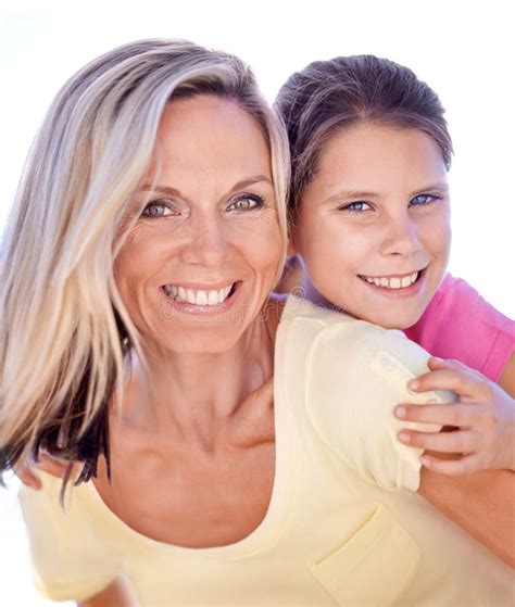 Sharing Bright Smiles A Smiling Mother With Her Daughter On Her Back While Outdoors Stock