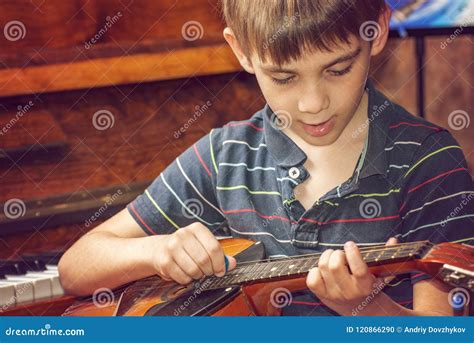 El Muchacho Toca La Guitarra Y Toma Los Acordes Dombra En El Fondo Del