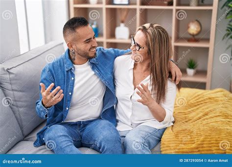 Man And Woman Mother And Son Sitting On Sofa Speaking At Home Stock