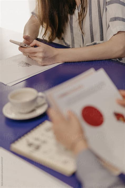 A Woman Using A Mobile Phone In The Office By Stocksy Contributor