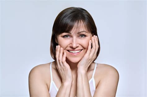 Retrato de mujer de mediana edad mirando a la cámara sobre fondo de