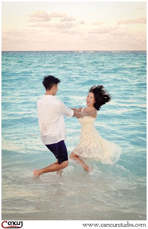 A Man And Woman Are Dancing In The Water