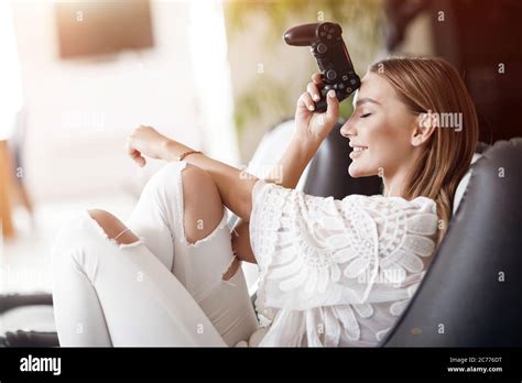 Smiling Woman Playing Video Games At Home With Joystick Stock Photo