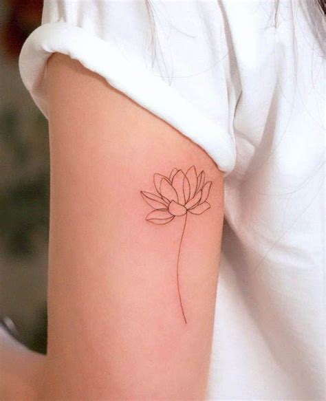 A Woman S Arm With A Single Flower Tattoo On The Back Of Her Left Arm