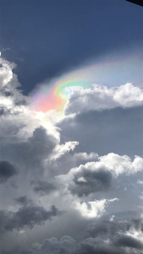 A Rainbow Appears In The Sky Above Some Clouds