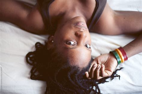 Portrait Of Black Woman Lying Head Down On A Bed Del Colaborador De