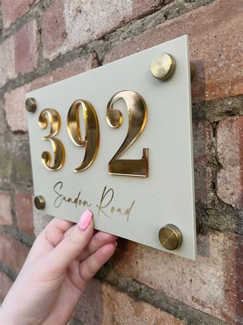 A Person Holding Up A Plaque With The Number Two In Gold On It That