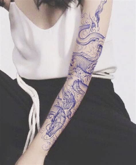 A Woman With A Dragon Tattoo On Her Arm