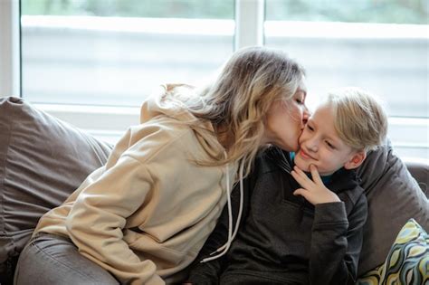 Heureuse Mère Et Fils D âge Scolaire Assis Sur Un Canapé Près De La