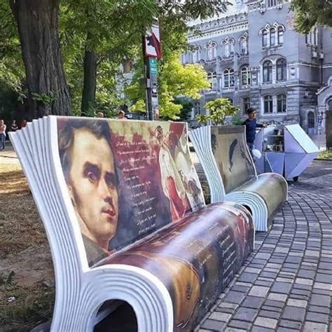 A Row Of Benches Sitting Next To Each Other On A Brick Walkway In Front