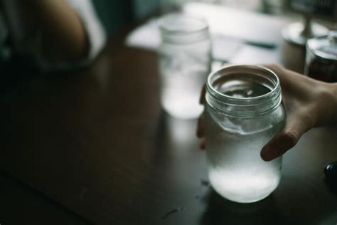 Premium Photo Person Holding Jar On Table