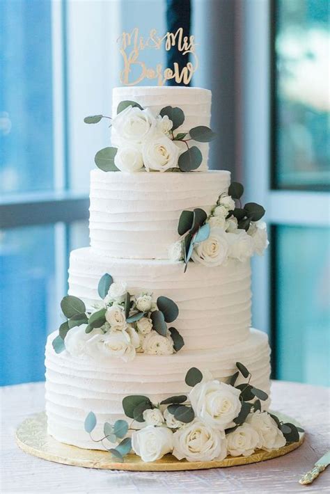 Awhite Textural Buttercream Wedding Cake Decorated With White Blooms