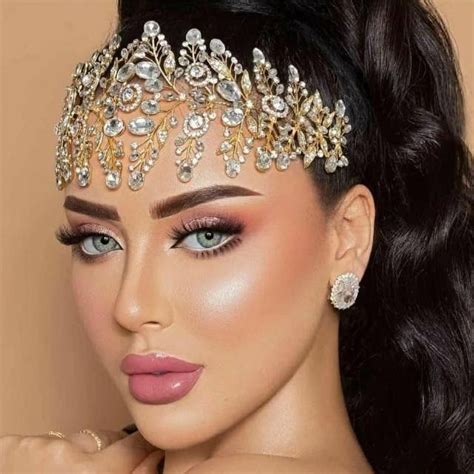 A Woman Wearing A Gold Headpiece With Pearls And Jewels On Her Forehead Is Posing For The Camera