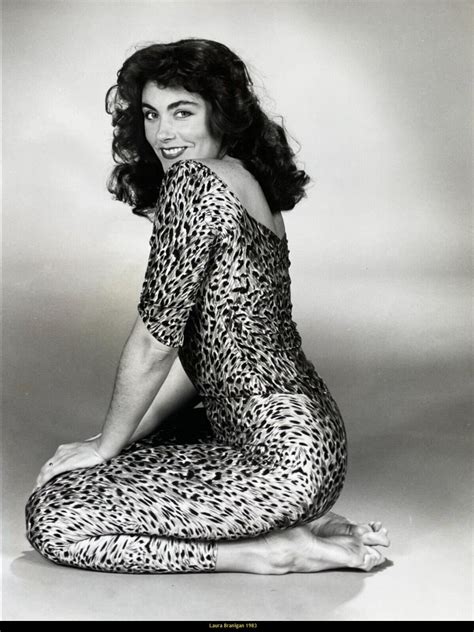 A Woman Sitting On The Ground Wearing A Leopard Print Dress And Smiling
