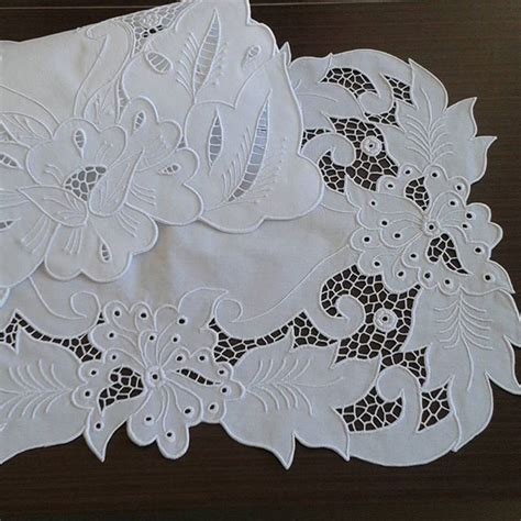 Two White Doily With Flowers And Butterflies On Them Are Sitting On A