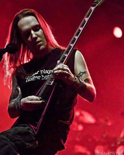 A Man With Long Hair Playing An Electric Guitar