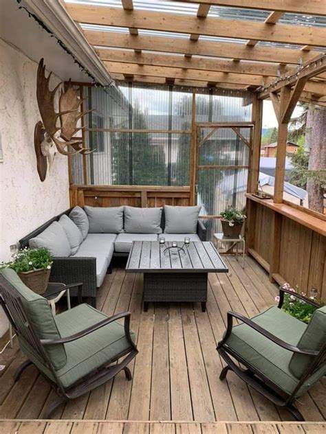 An Outdoor Living Area With Couches Tables And Plants On The Decking Floor