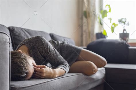 Pensive Woman Lying Down On Sofa Stock Photo OFFSET