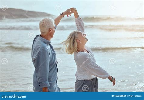 a happy mature caucasian couple enjoying fresh air on vacation at the beach smiling retired