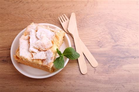 Pastel de capas napoleón con una rodaja de crema de leche de vainilla