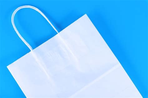 Bolsa De Papel Blanca Con Asas Sobre Fondo Azul Foto Premium