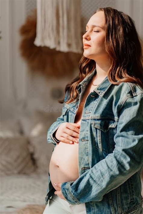Una Hermosa Mujer Embarazada Con Una Chaqueta De Denim Con Una Panza