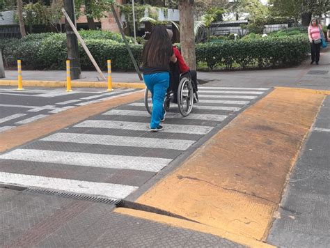 Persona En Silla De Ruedas Cruzando Por Un Cruce Peatonal A Nivel