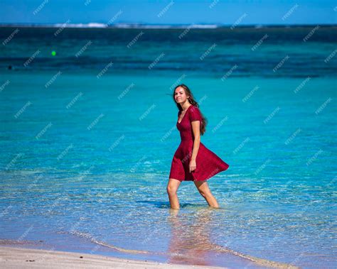 Premium Photo Beautiful Long Haired Girl In A Dress Soaks Her Feet In The Water In Turquoise