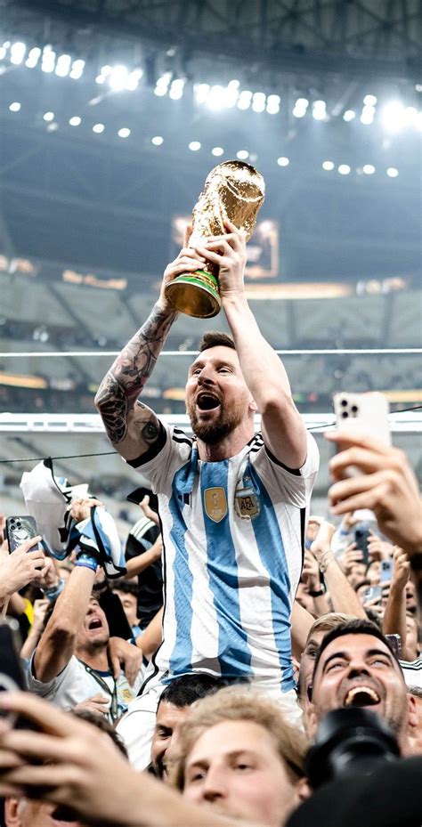 A Man Holding Up A Trophy In Front Of A Group Of People At A Sporting Event