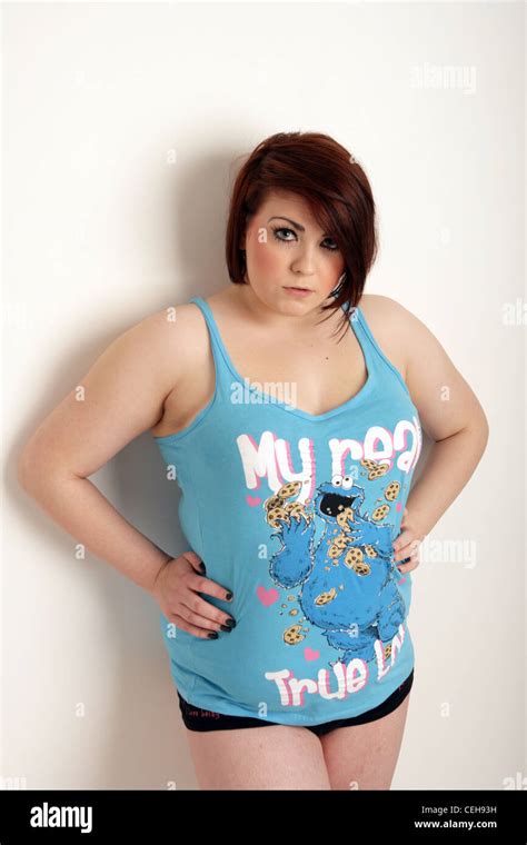 Overweight Woman Standing Against Wall Wearing Shorts And T Shirt Stock