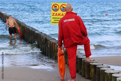 Ratownik na plaży podczas patrolowania brzegu wody nad morzem latem