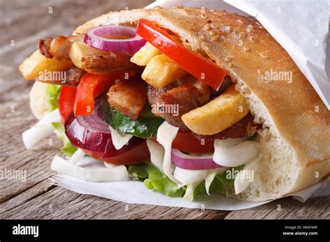 Doner Kebab With Meat Vegetables And Fries In Pita Bread Wrapped In