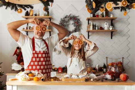 Padre e hija cocinando comida navideña y jugando Foto Premium