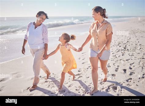 Familie lächelt am Strand Mama und Großmutter halten sich im Urlaub