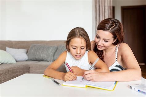Madre Ayudando A Su Hija A Hacer Su Tarea Foto Gratis