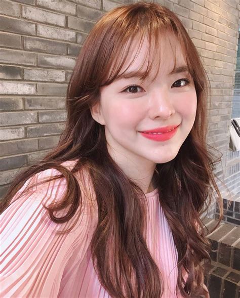A Woman With Long Brown Hair Is Smiling At The Camera