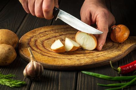El Cocinero Corta La Cebolla Con Un Cuchillo En Una Tabla De Cortar