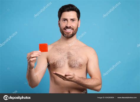 Hombre Desnudo Sosteniendo Condón Sobre Fondo Azul Claro Sexo Seguro
