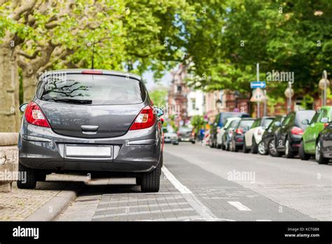 Rows Of Cars Parked On The Roadside In Residential District Stock Photo